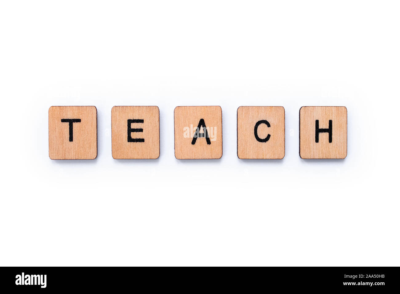 The word TEACH, spelt with wooden letter tiles over a white background ...