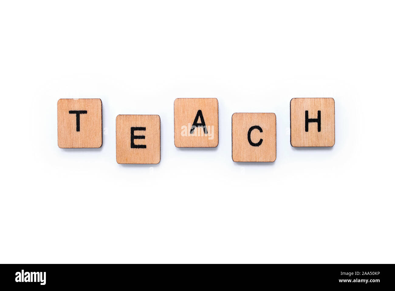 The word TEACH, spelt with wooden letter tiles over a white background ...