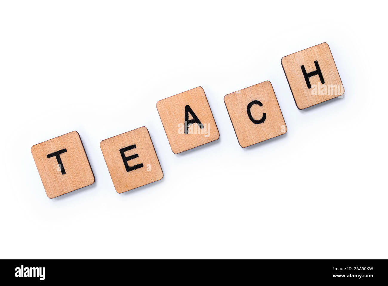 The word TEACH, spelt with wooden letter tiles over a white background ...