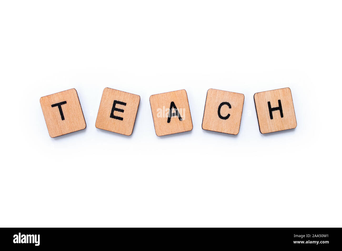 The word TEACH, spelt with wooden letter tiles over a white background ...