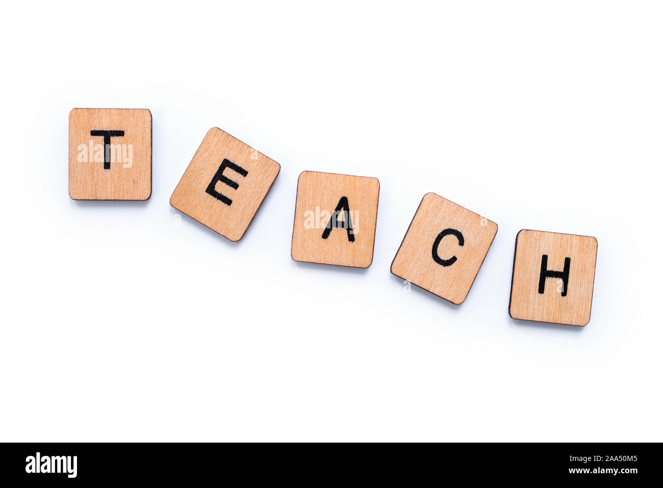 The word TEACH, spelt with wooden letter tiles over a white background ...