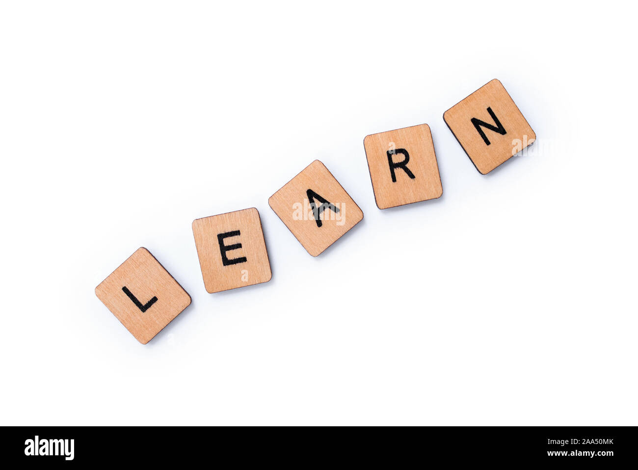 The word LEARN, spelt with wooden letter tiles over a white background ...