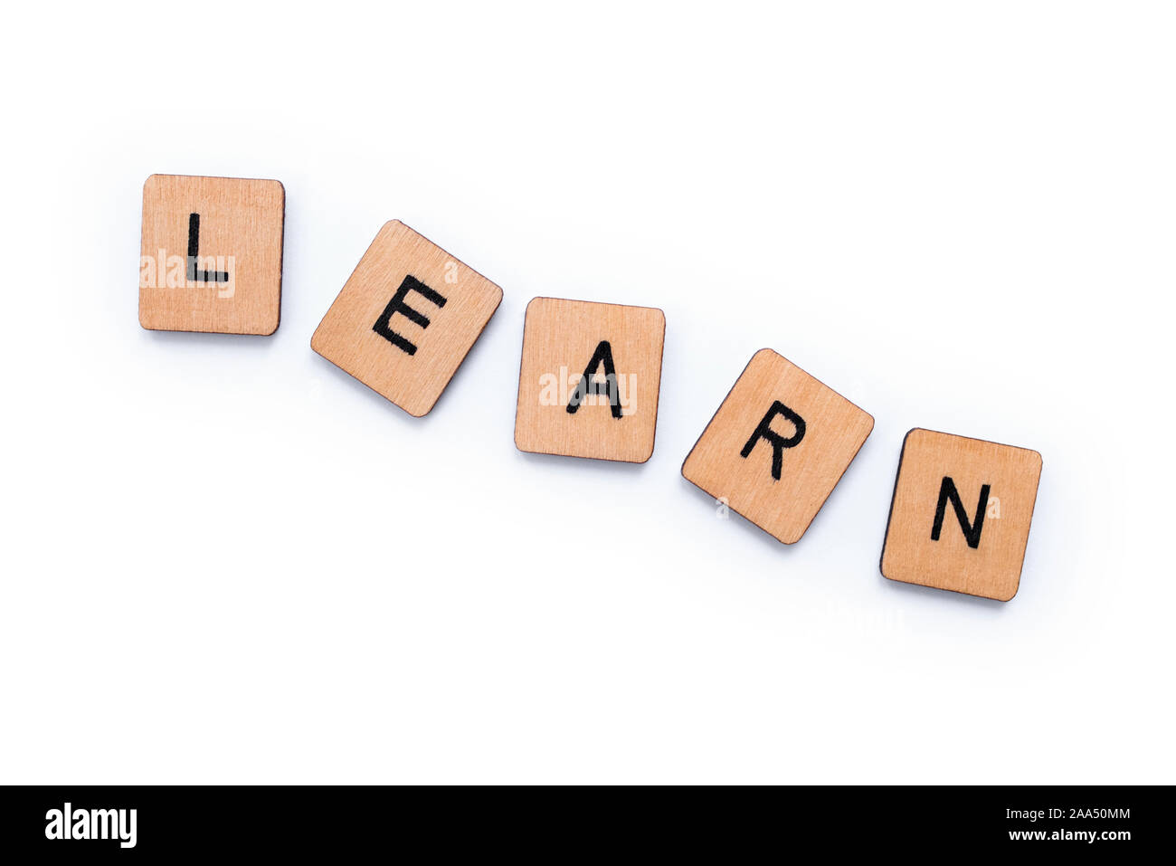 The word LEARN, spelt with wooden letter tiles over a white background ...