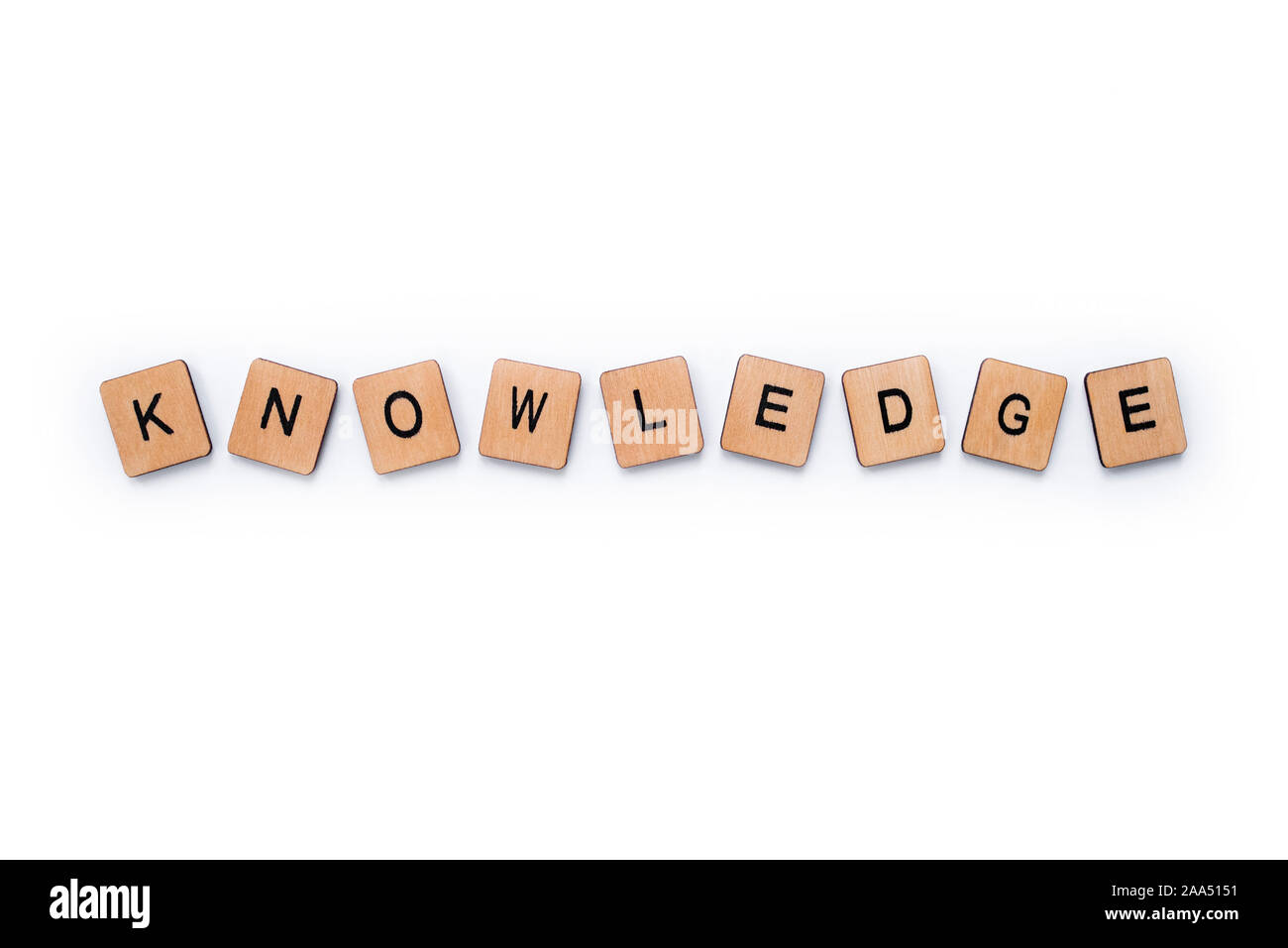 The word KNOWLEDGE, spelt with wooden letter tiles over a white ...