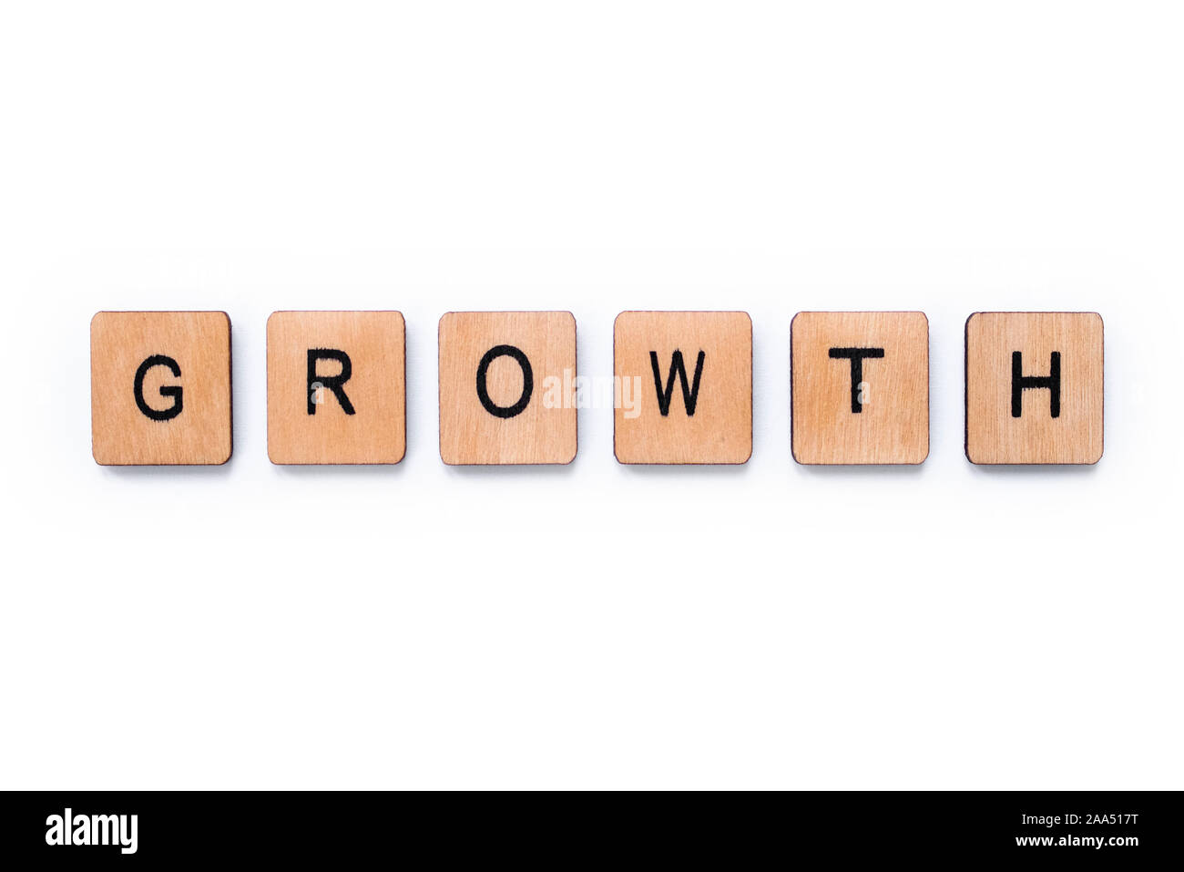 The word GROWTH, spelt with wooden letter tiles over a white background ...