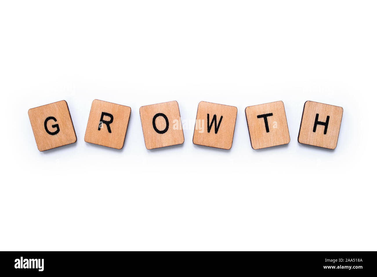 The word GROWTH, spelt with wooden letter tiles over a white background ...
