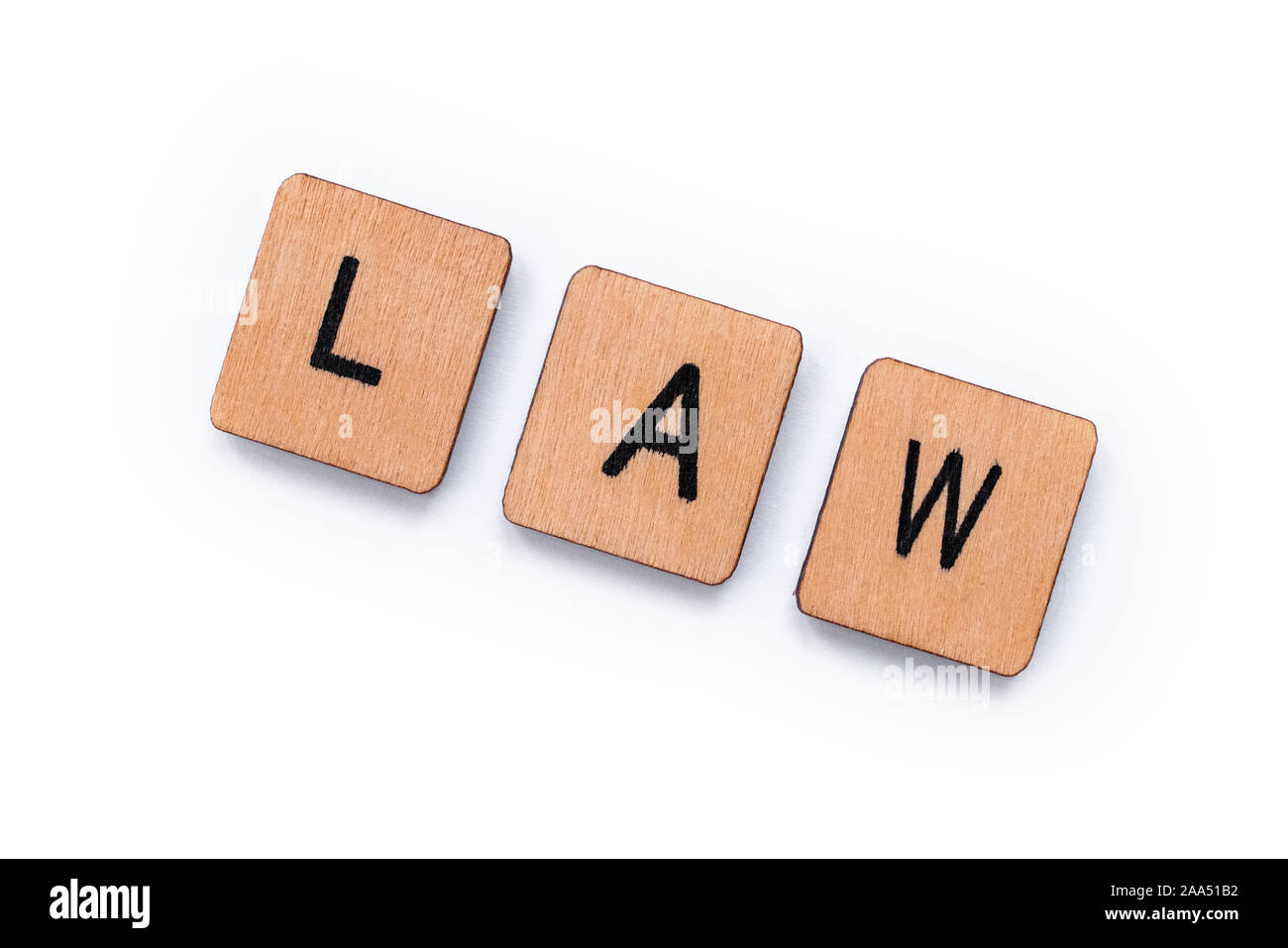 The word LAW, spelt with wooden letter tiles over a white background ...