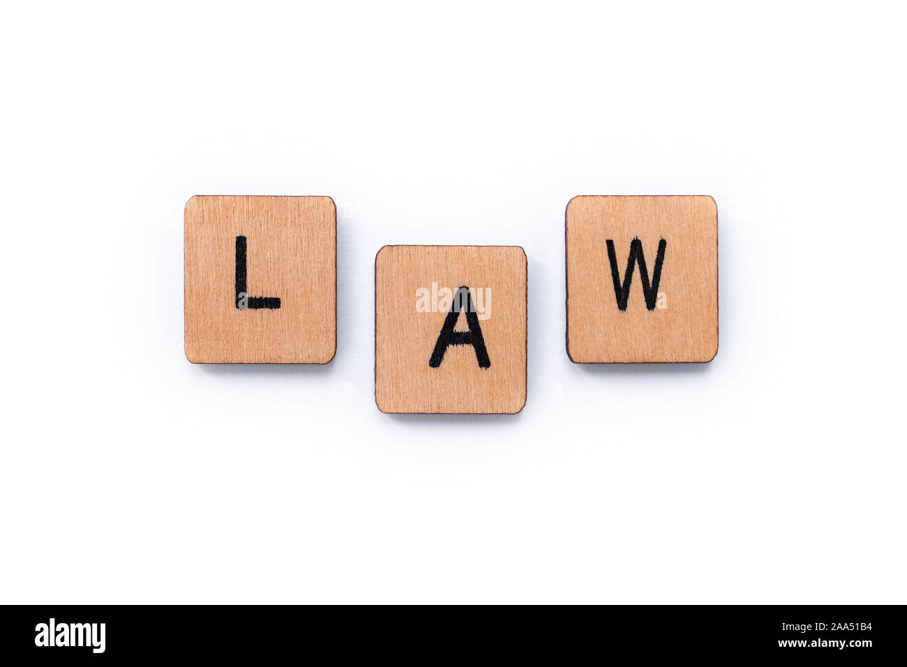 The word LAW, spelt with wooden letter tiles over a white background ...