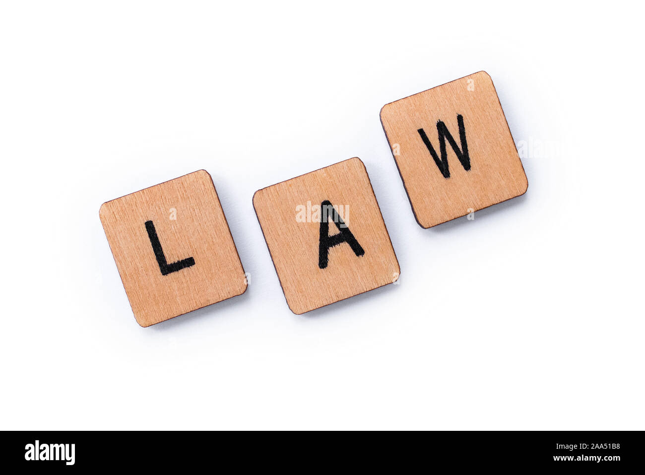 The word LAW, spelt with wooden letter tiles over a white background ...