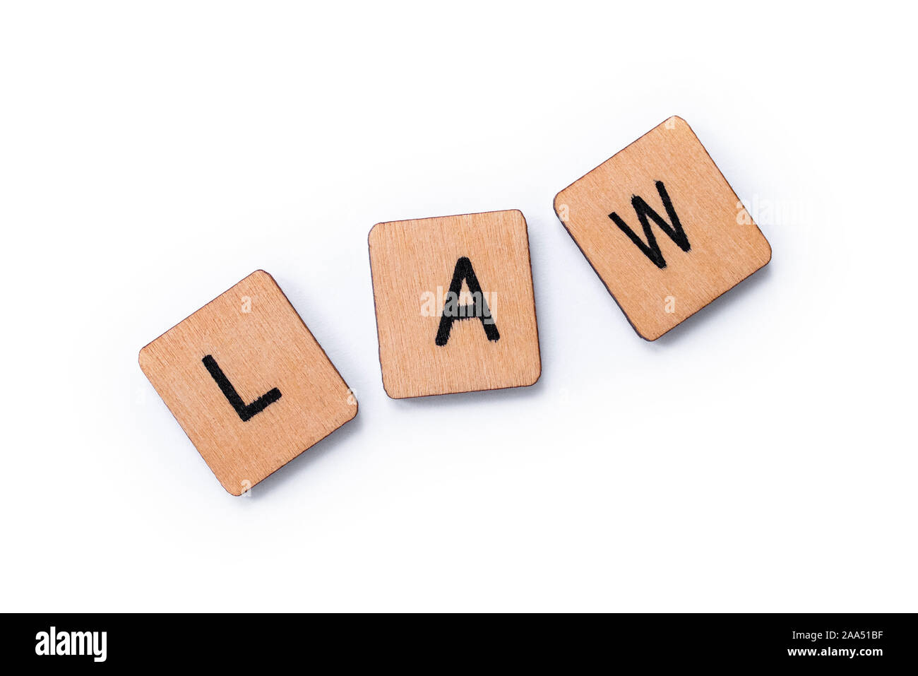The word LAW, spelt with wooden letter tiles over a white background ...