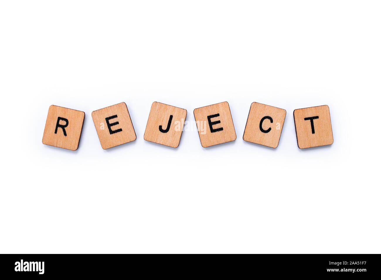 The word REJECT, spelt with wooden letter tiles over a white background ...