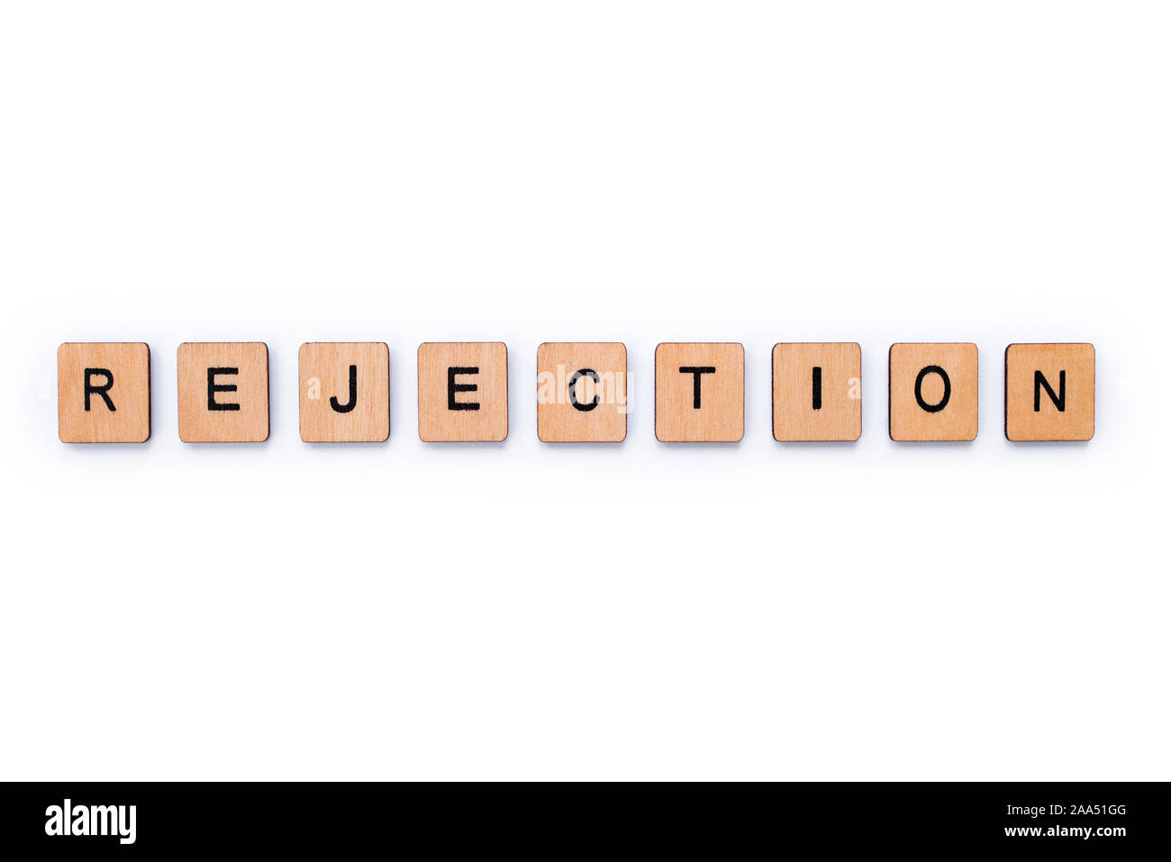 The word REJECTION, spelt with wooden letter tiles over a white ...