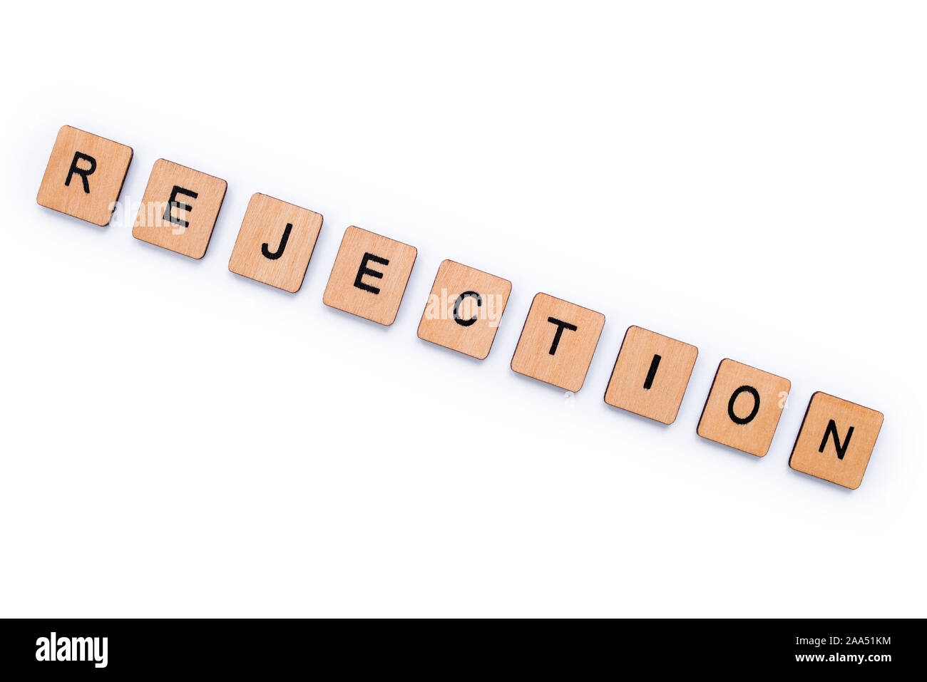 The word REJECTION, spelt with wooden letter tiles over a white ...