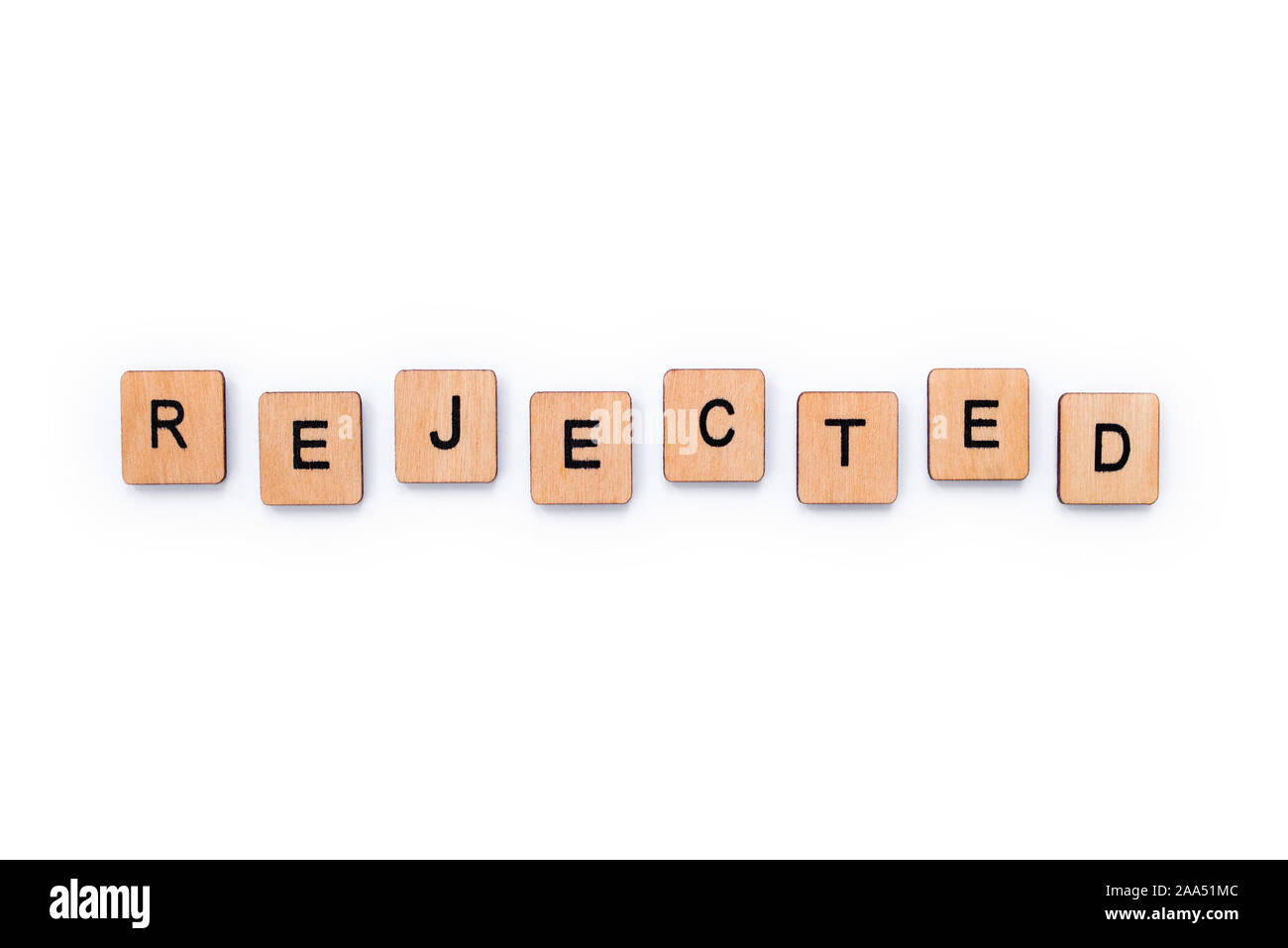 The word REJECTED, spelt with wooden letter tiles over a white ...