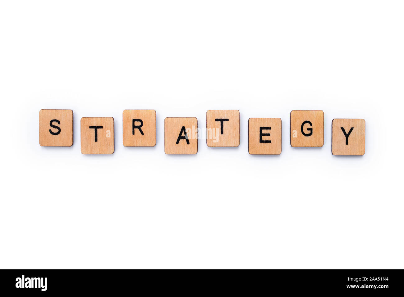 The word STRATEGY, spelt with wooden letter tiles over a white ...