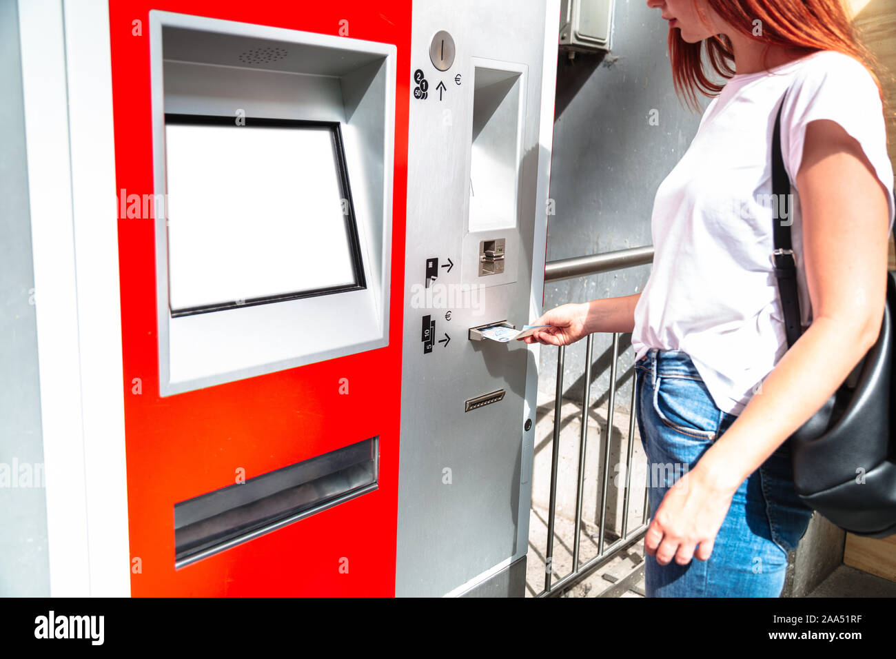 Woman buying ticket at terminal with euro note Stock Photo - Alamy