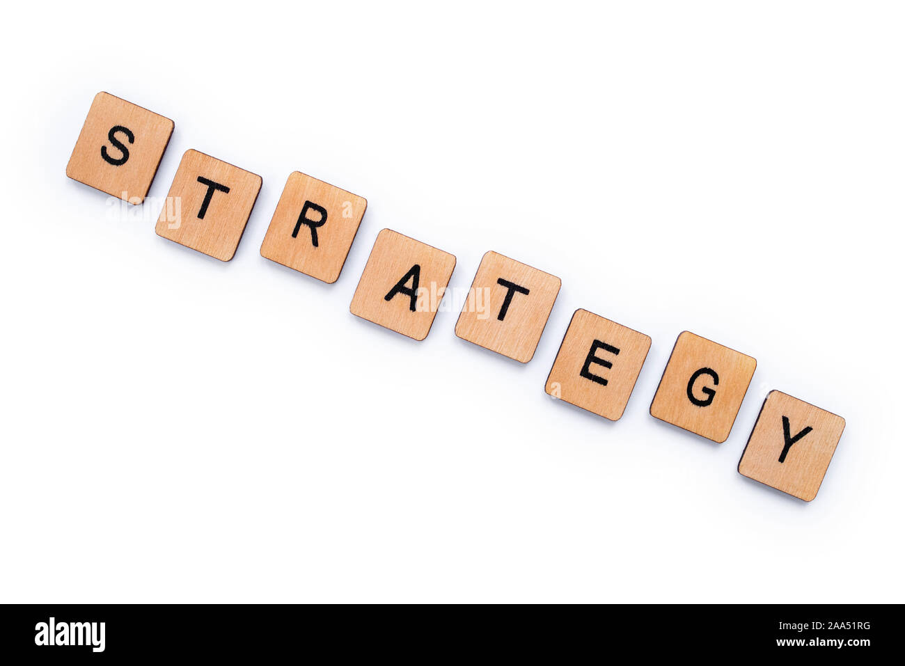 The word STRATEGY, spelt with wooden letter tiles over a white ...