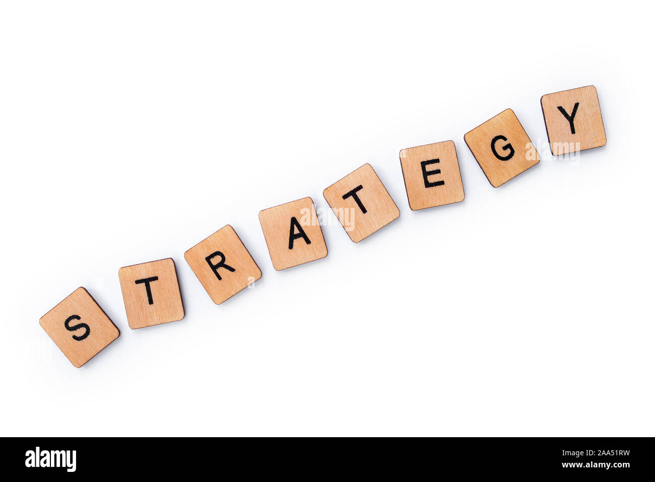 The word STRATEGY, spelt with wooden letter tiles over a white ...