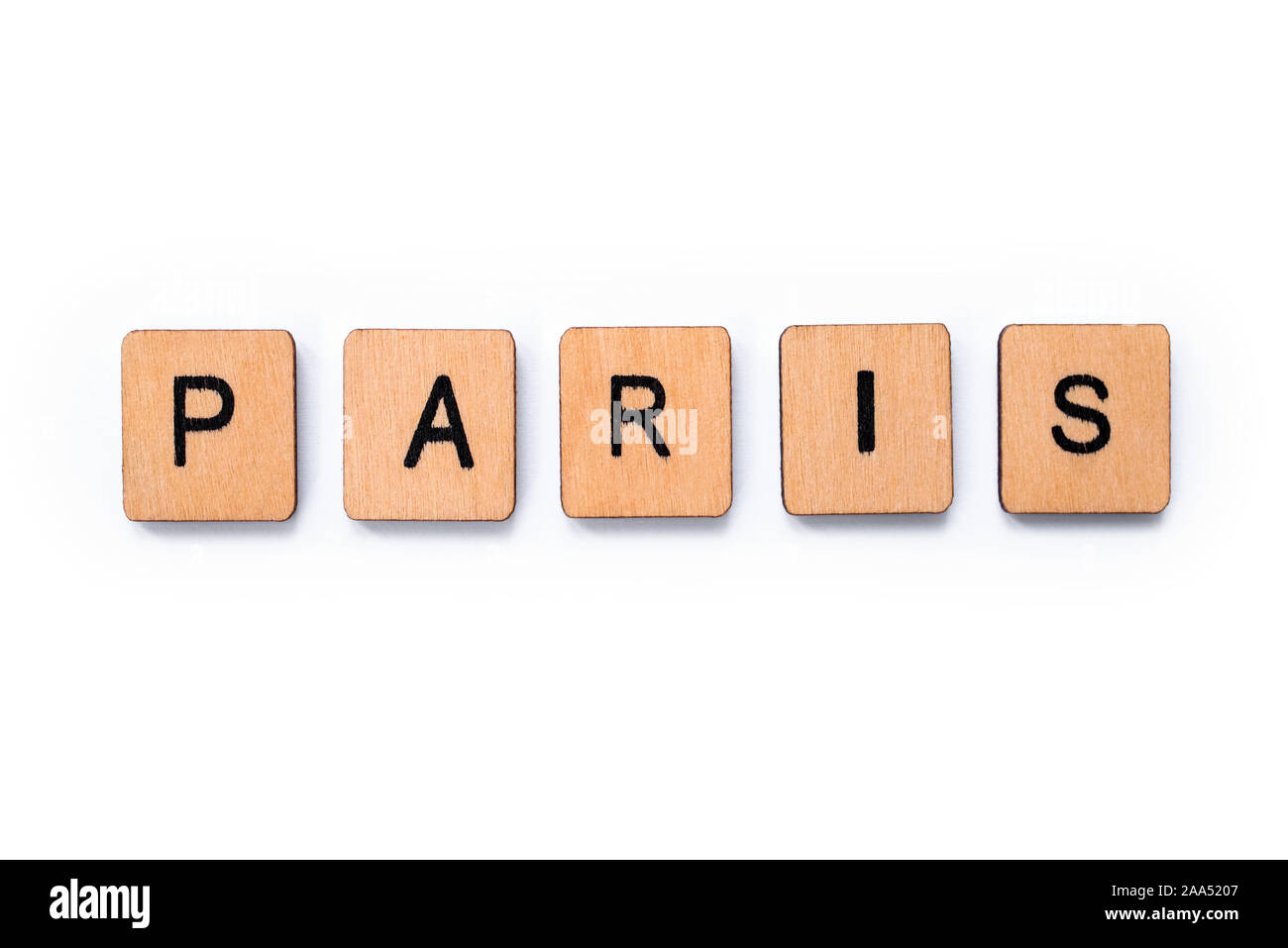 The word PARIS, spelt with wooden letter tiles over a white background ...