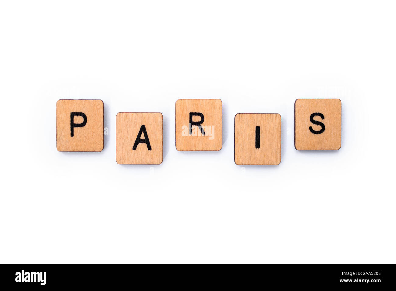 The word PARIS, spelt with wooden letter tiles over a white background ...