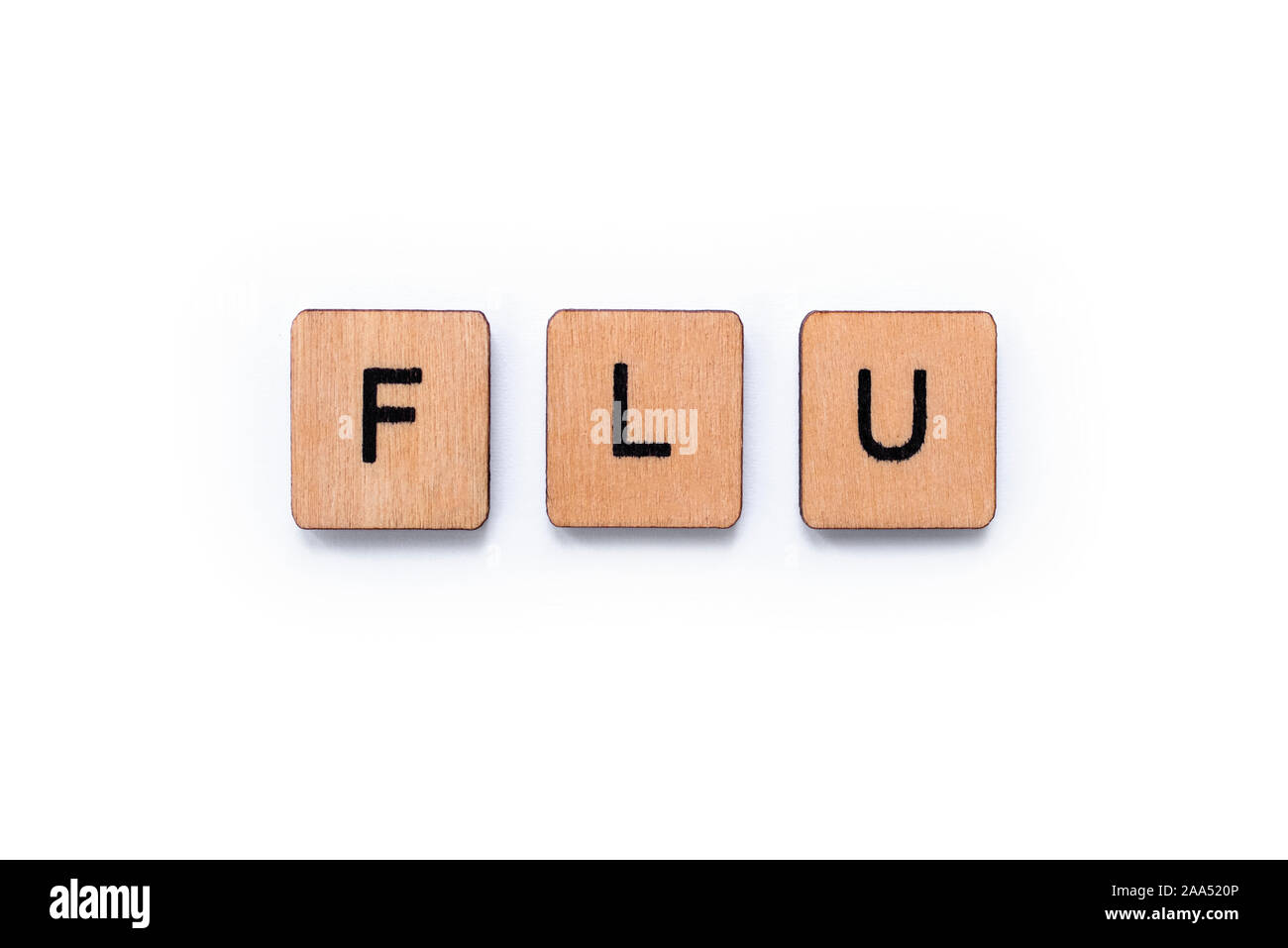 The word FLU, spelt with wooden letter tiles over a white background ...