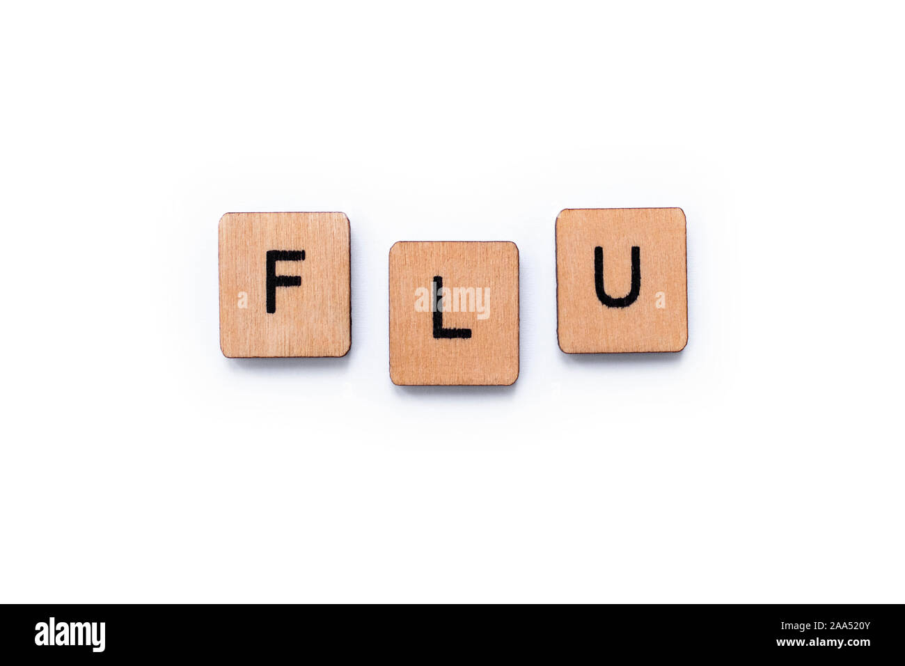 The word FLU, spelt with wooden letter tiles over a white background ...