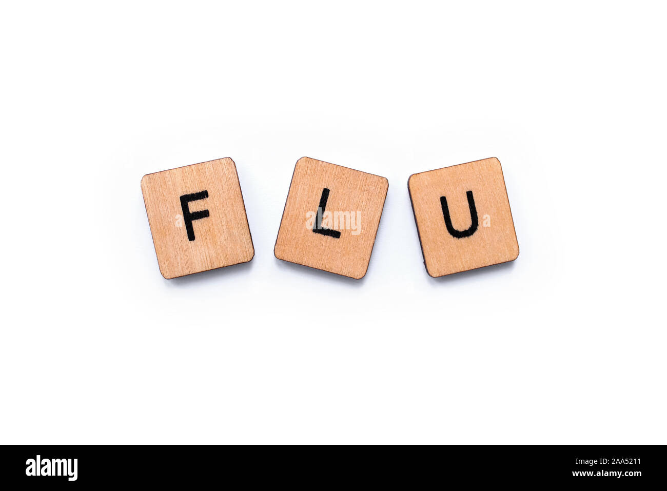 The word FLU, spelt with wooden letter tiles over a white background ...