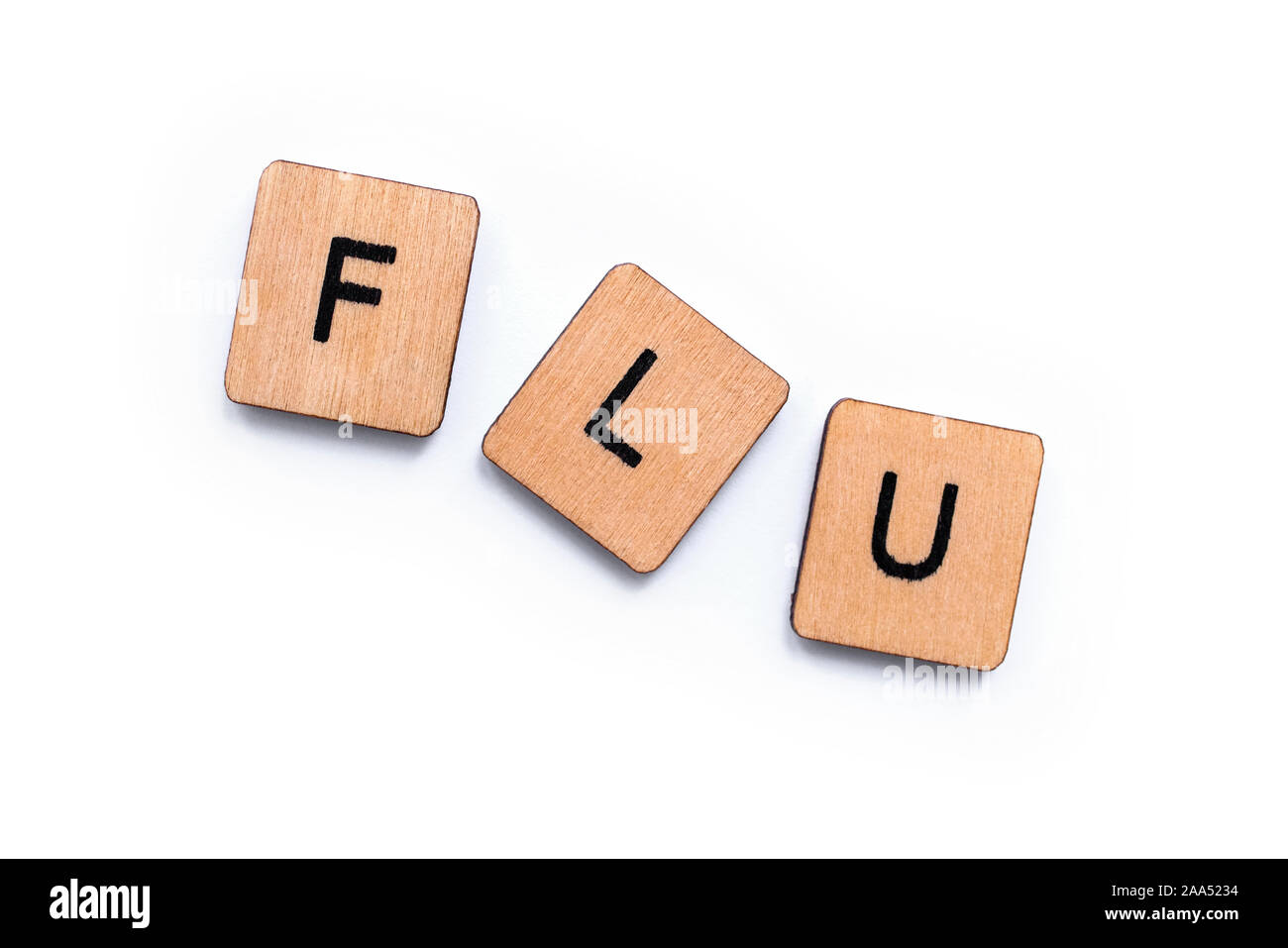 The word FLU, spelt with wooden letter tiles over a white background ...