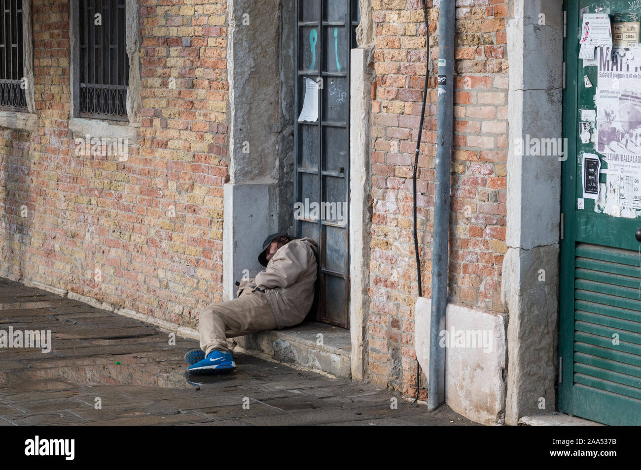 Homeless man sleeping on door threshold Stock Photo - Alamy