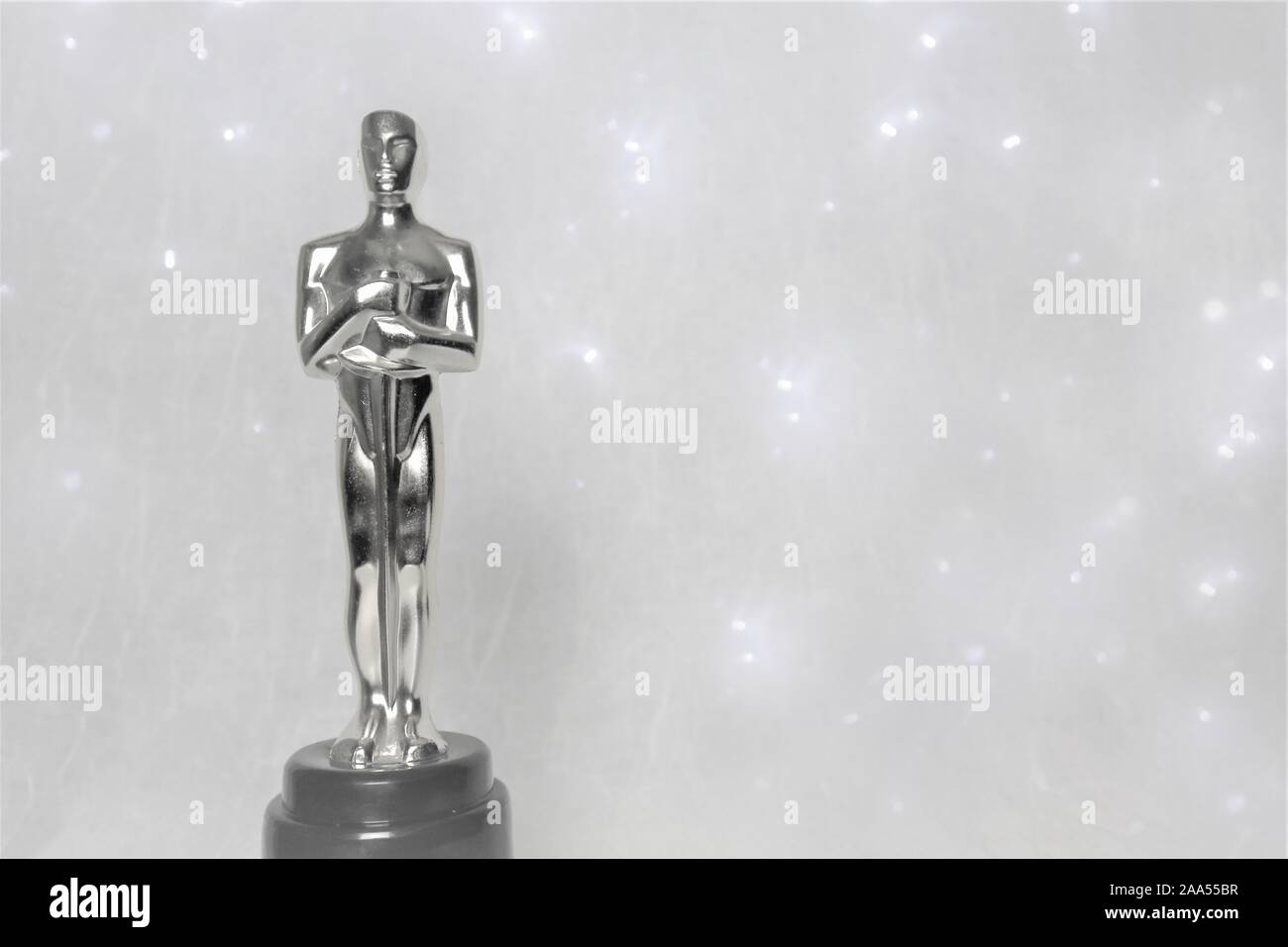 The golden statue of Oscar on a white background, with illumination ...