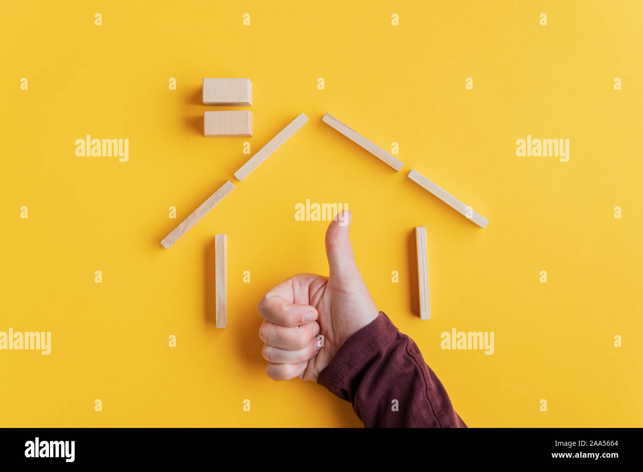 Male hand making a thumbs up gesture holding his hand inside a house ...
