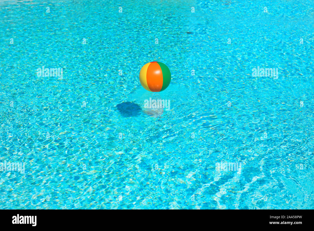 Inflatable colorful beach ball floating in water Stock Photo - Alamy