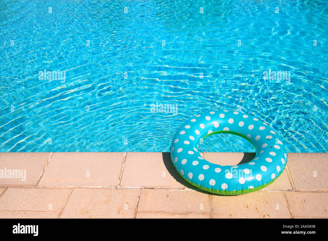 Spotted blue inflatable ring in swimming pool Stock Photo - Alamy