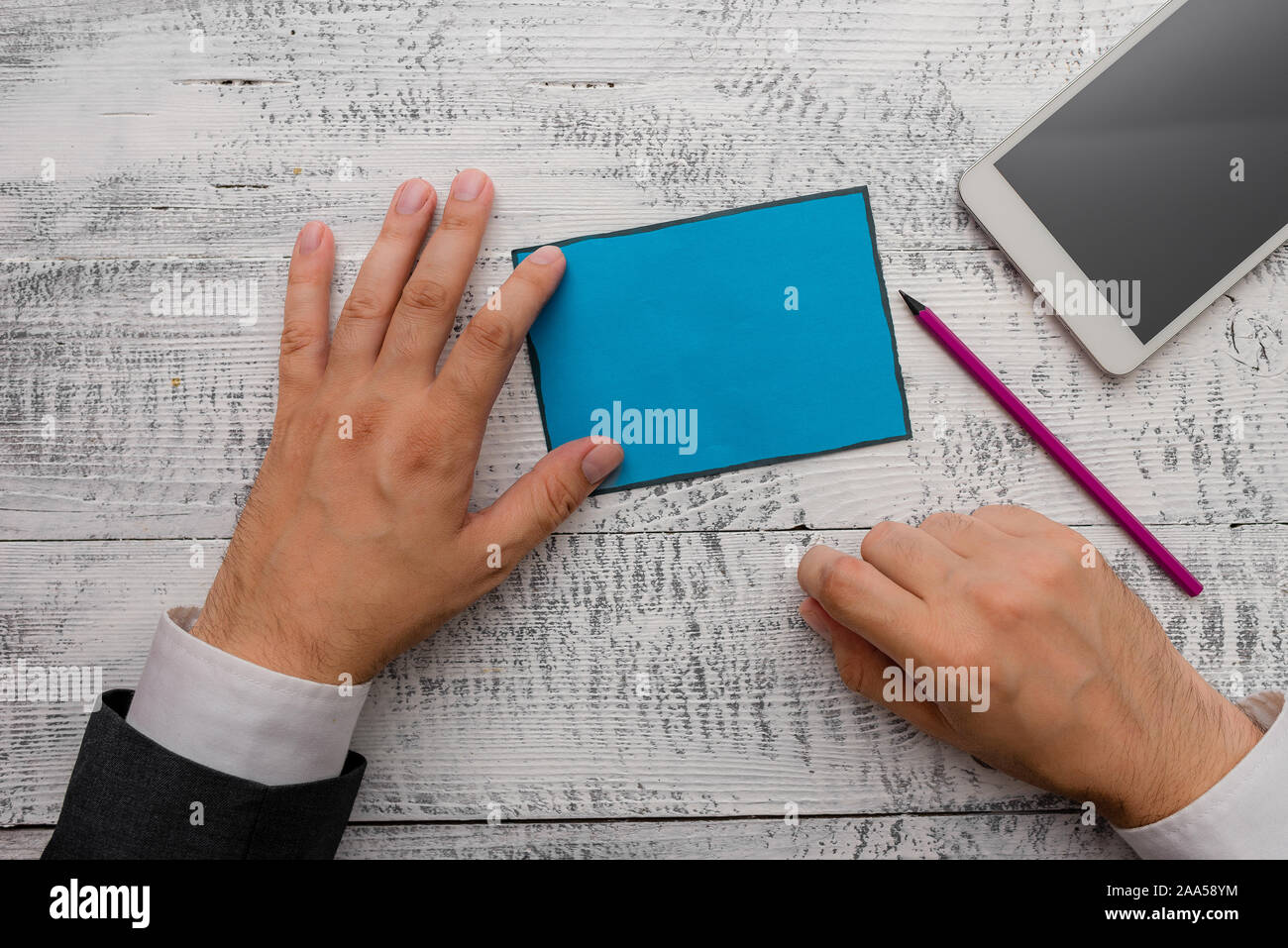 Hand hold note paper near writing equipment and modern smartphone ...