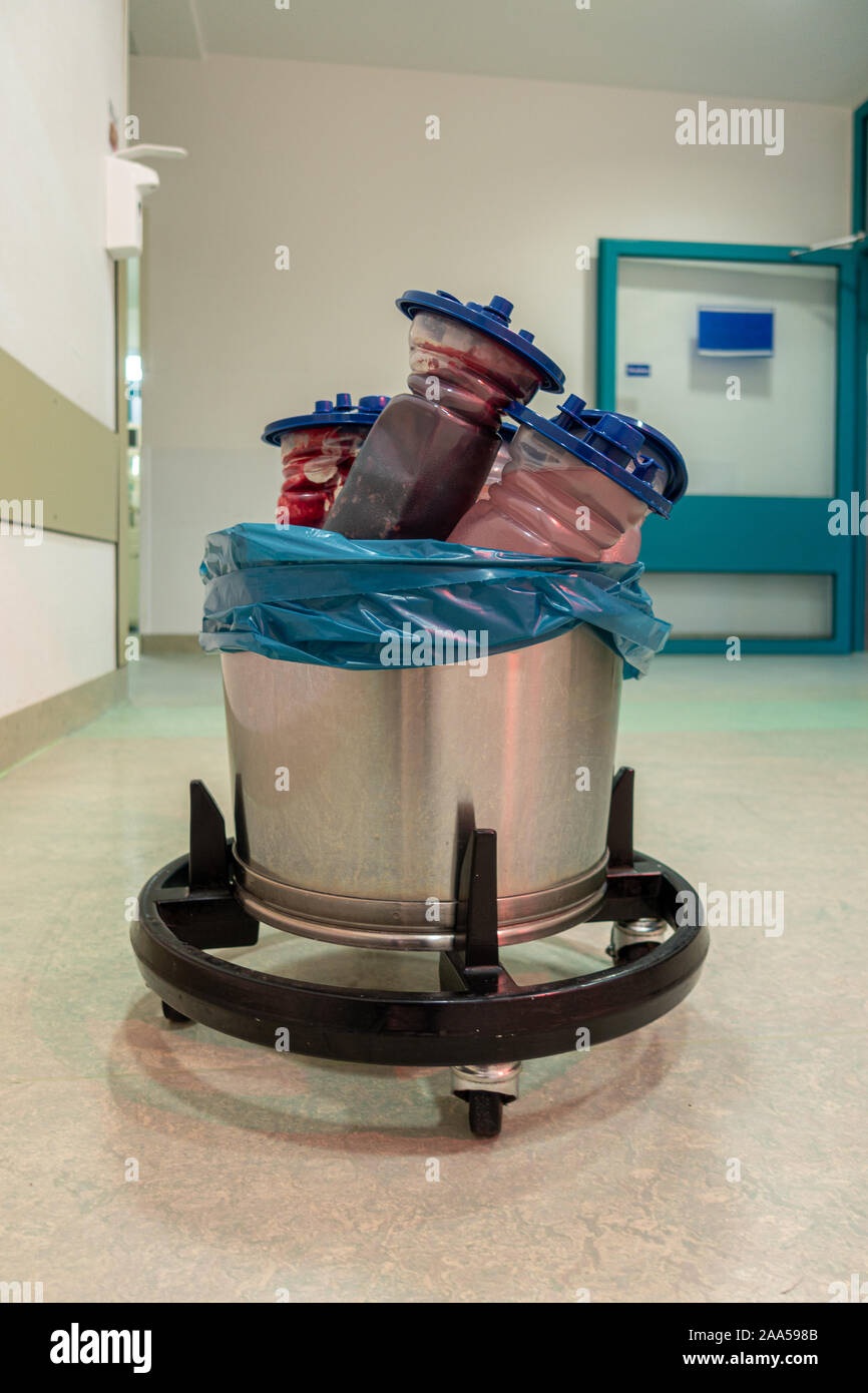 in a trash can in an operating theatre there are various suction ...