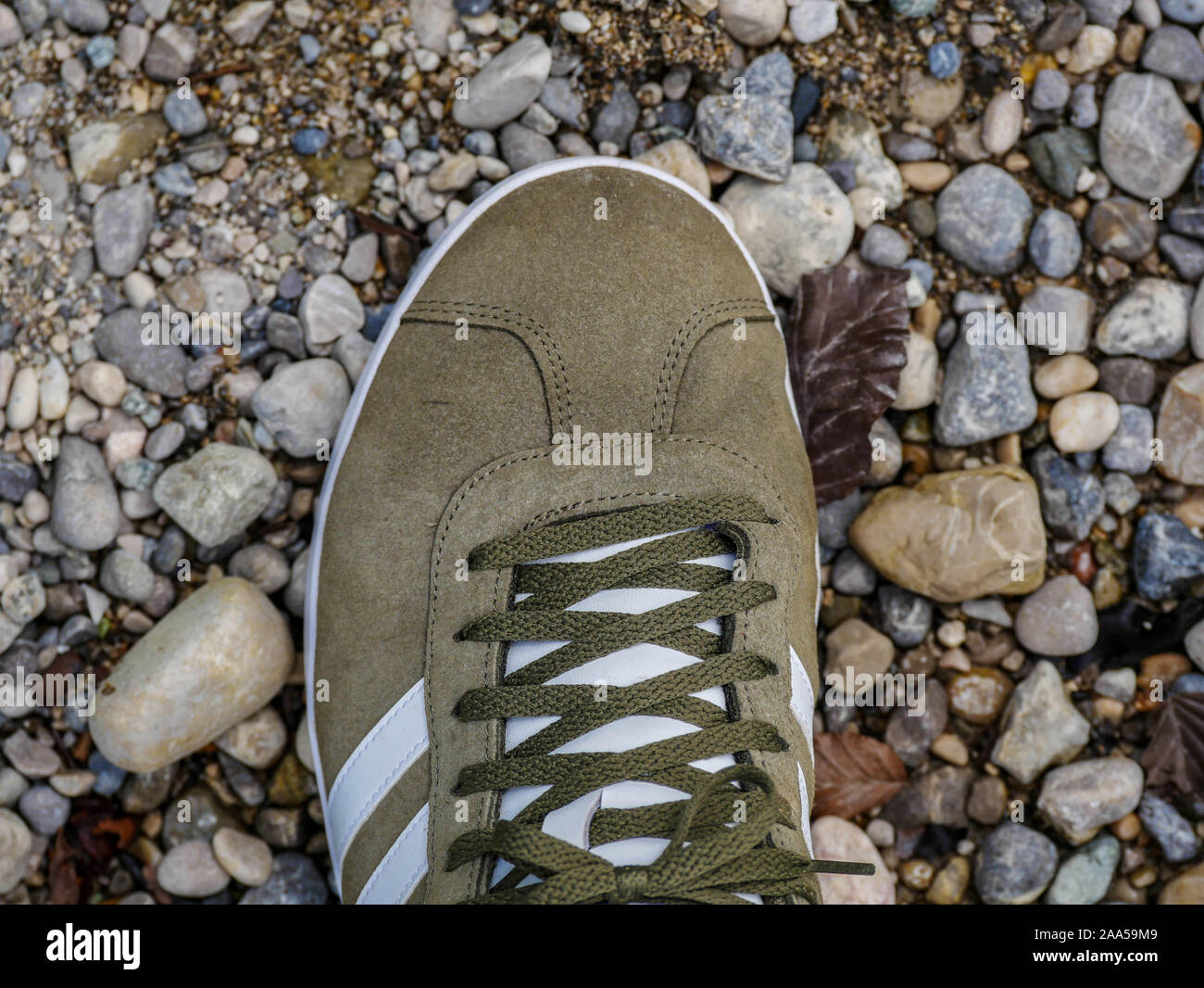 Top down view on green shoe on stone ground Stock Photo - Alamy