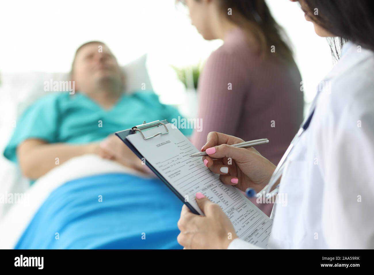 Doctor filling form about condition of patient Stock Photo - Alamy