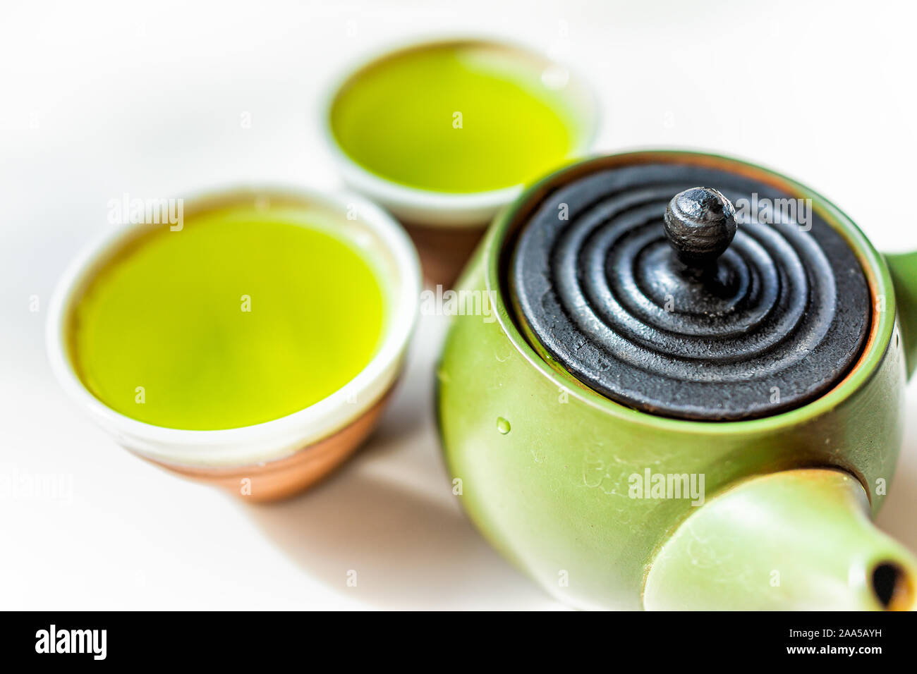 Kyusu teapot and two cups filled with Japanese vibrant green yellow ...