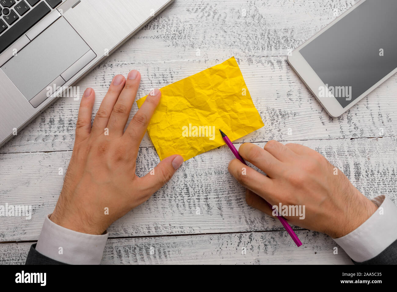 Hand hold note paper near writing equipment and modern smartphone ...