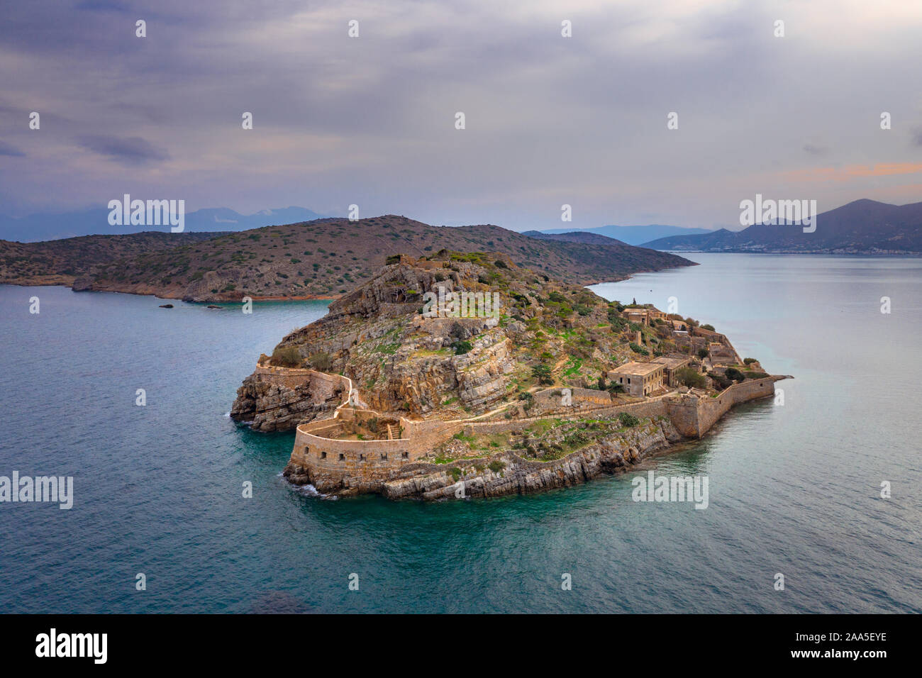 Aerial view of the island of Spinalonga with calm sea. Here were ...