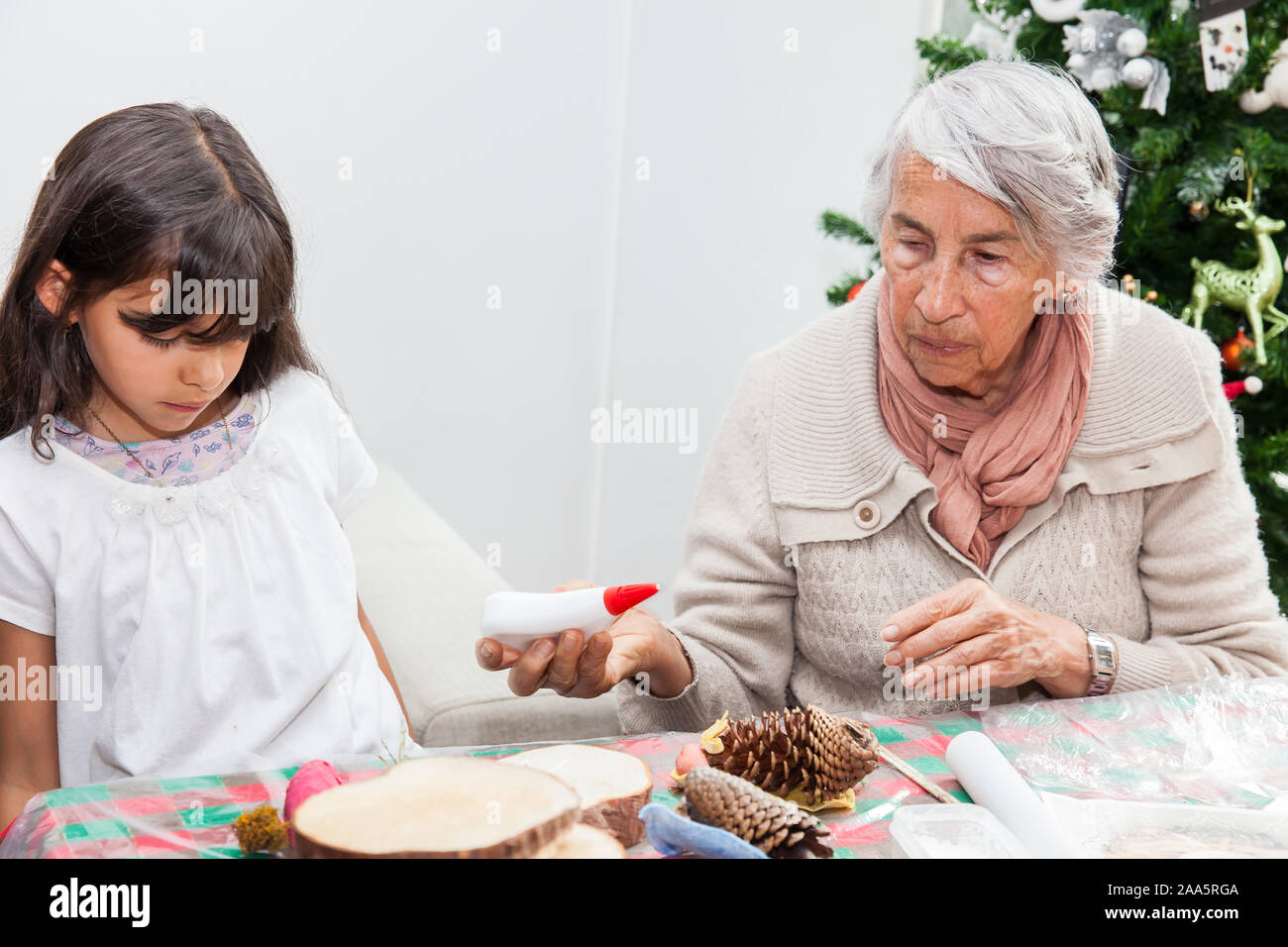 Grandmother teaching her granddaughter how to make christmas Nativity ...