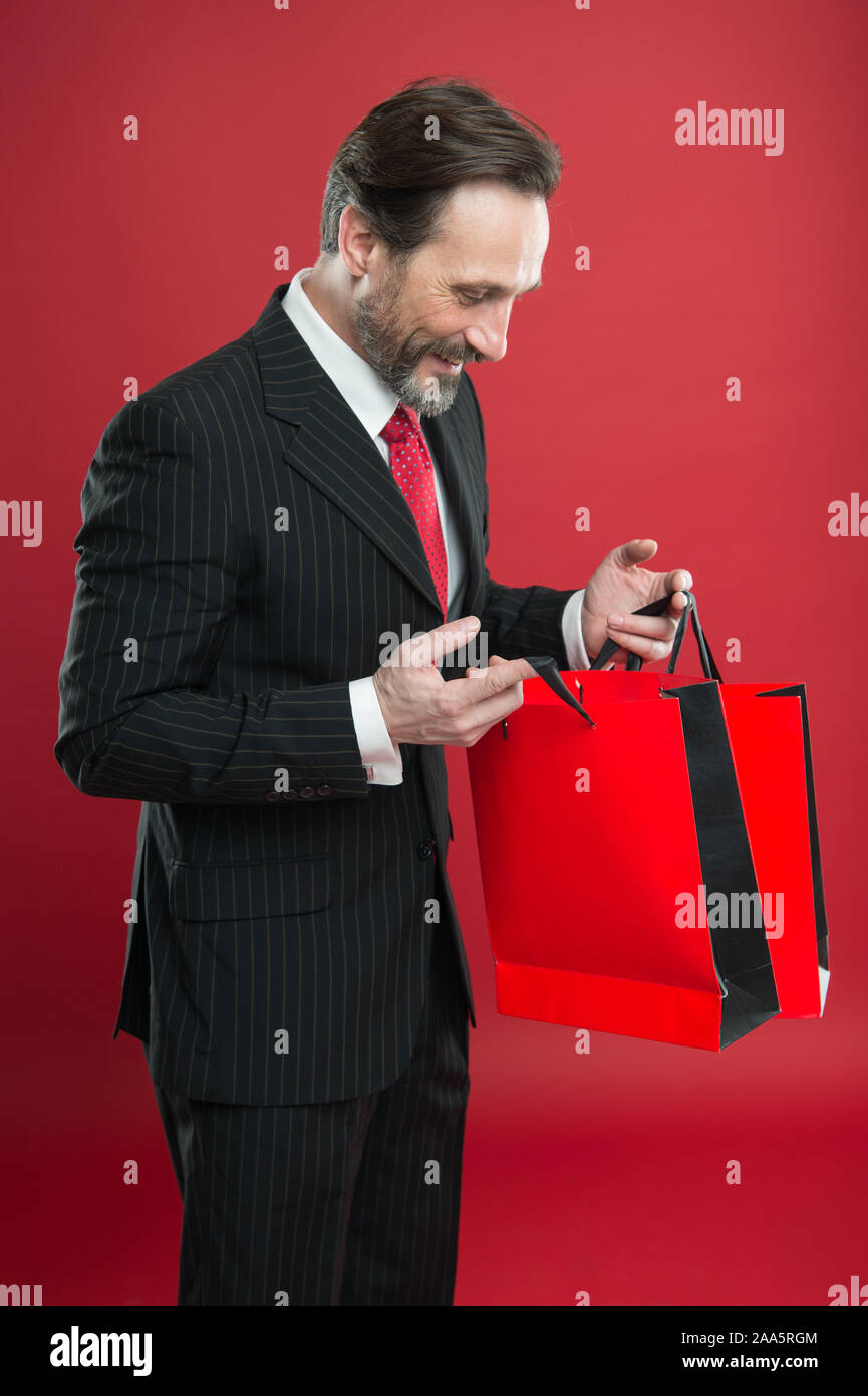 Shocking discount. Mature businessman hold paper bag gift red ...