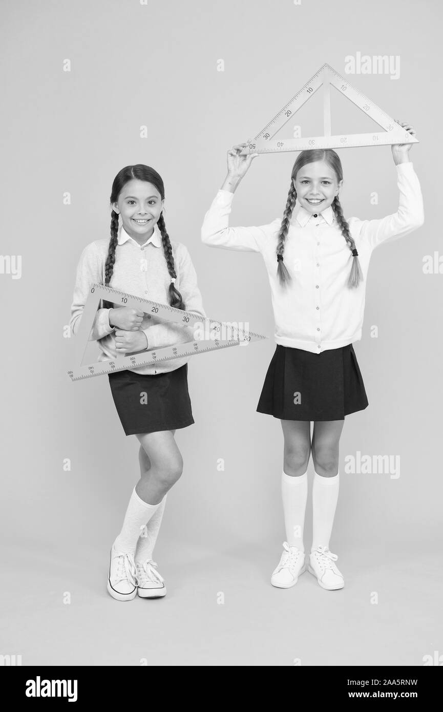 Measuring angles at geometry. Cute schoolgirls holding triangles for ...