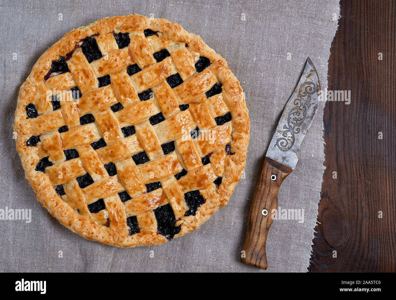 whole baked round black currant cake on brown wooden background, top ...
