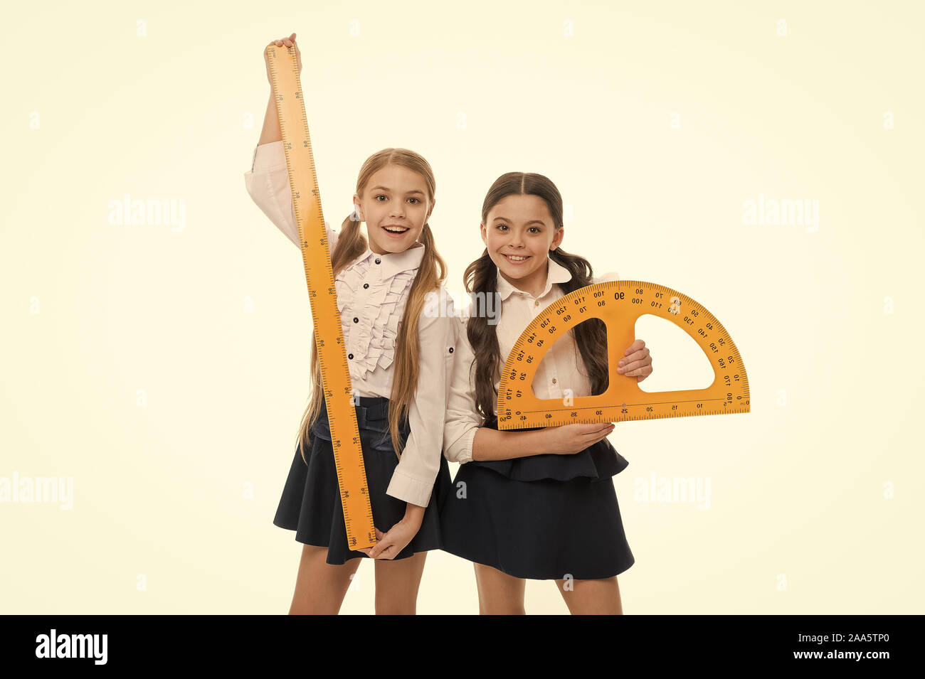 Being ready for lesson. Cute schoolgirls holding protractor and ruler ...