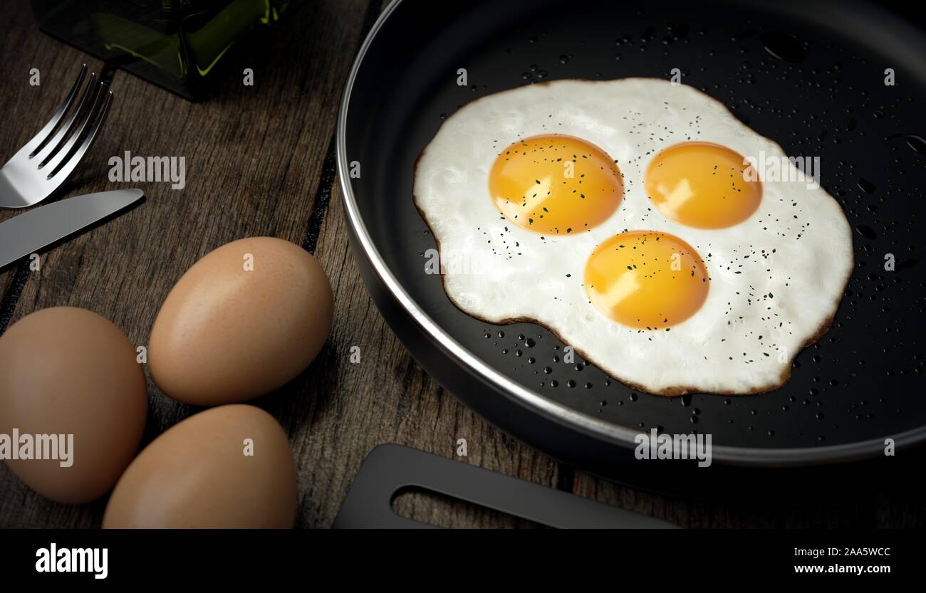Egg with three yolks on a pan Stock Photo - Alamy