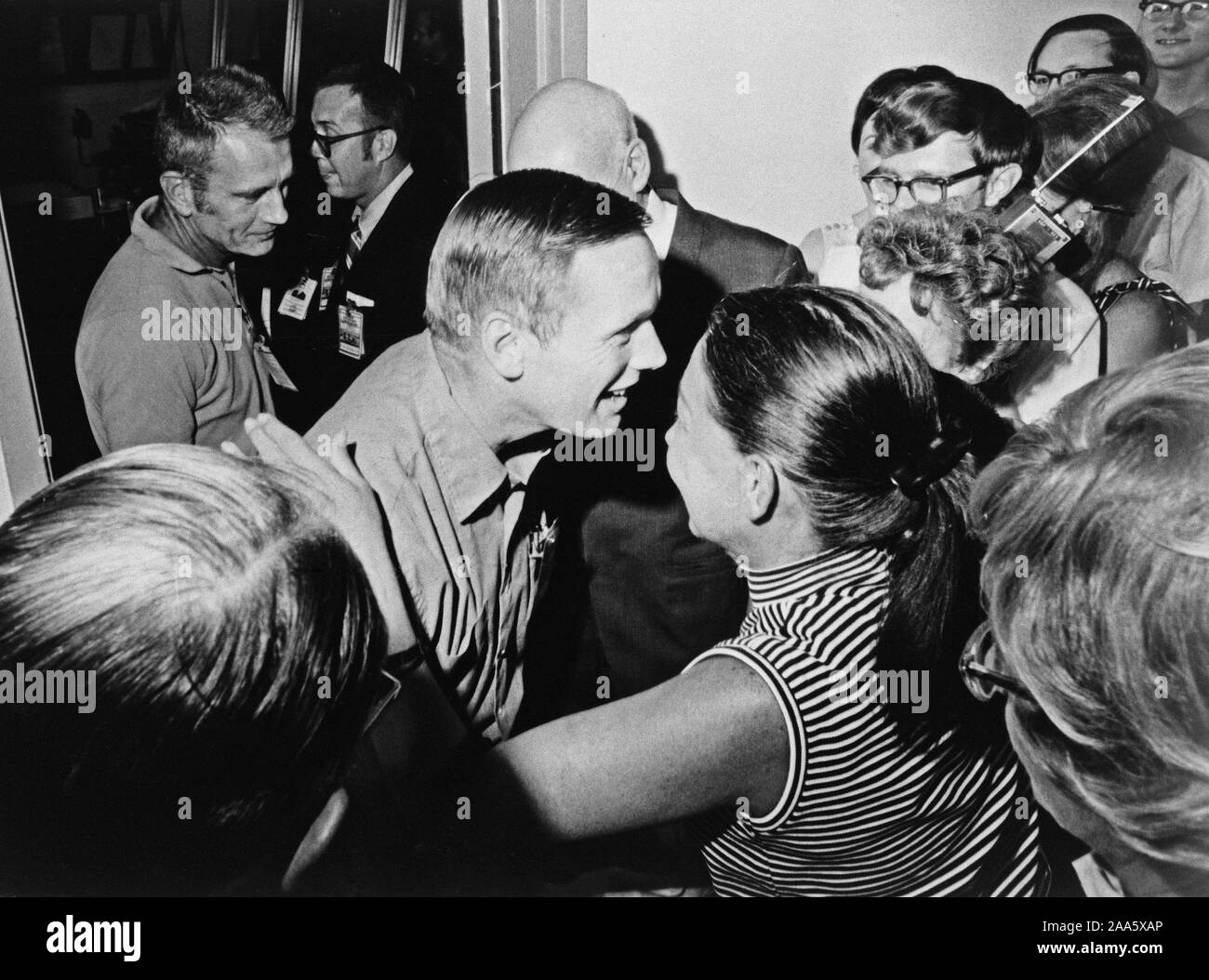 Astronaut Neil A. Armstrong (center), is greeted by friends in the crew ...