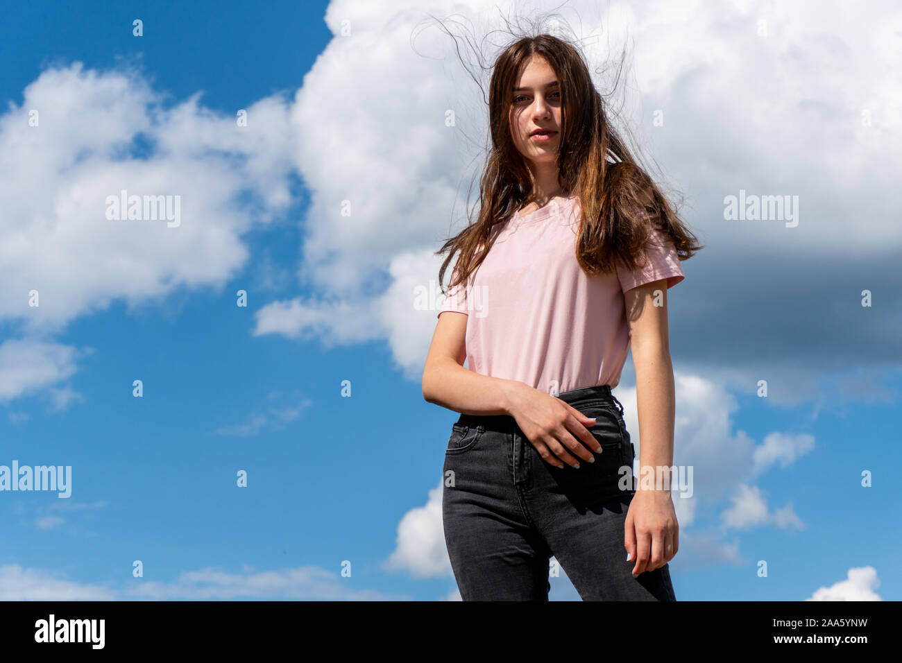 Teen girl looking in camera and posing with sky at background Stock ...