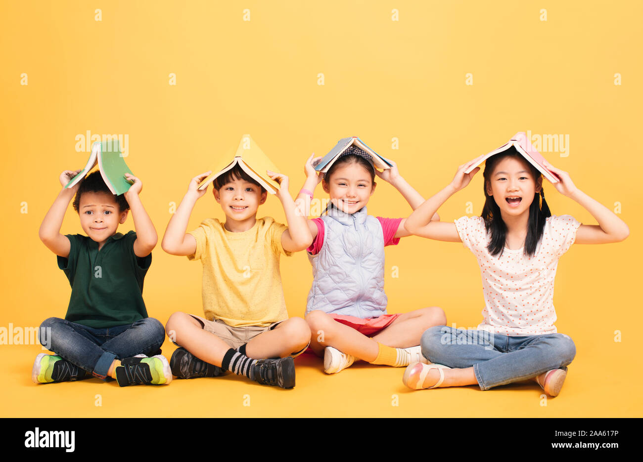 Happy children sitting together on ground Stock Photo - Alamy