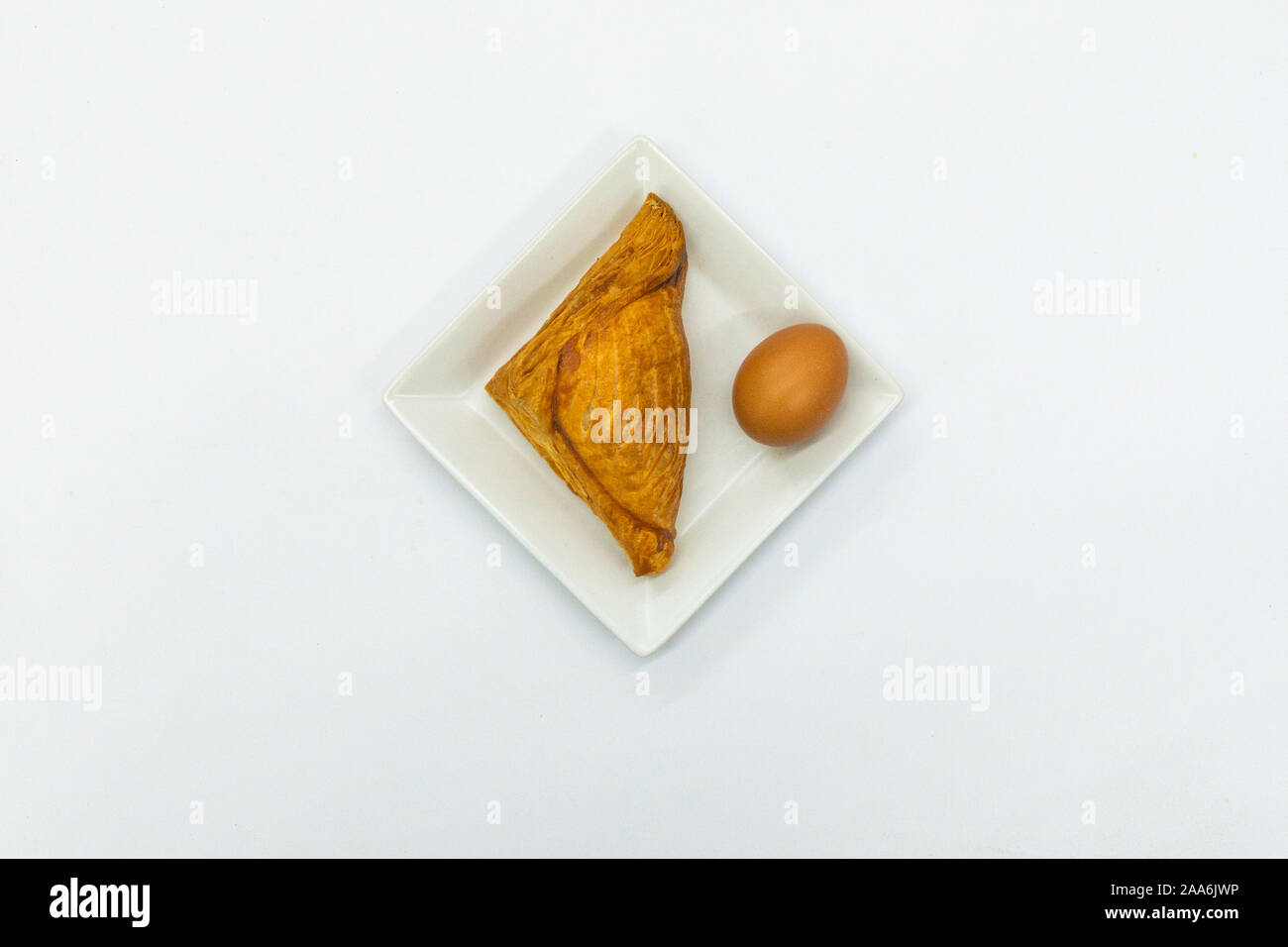 Plain egg turnover on white plate and background. Empty copy space for ...
